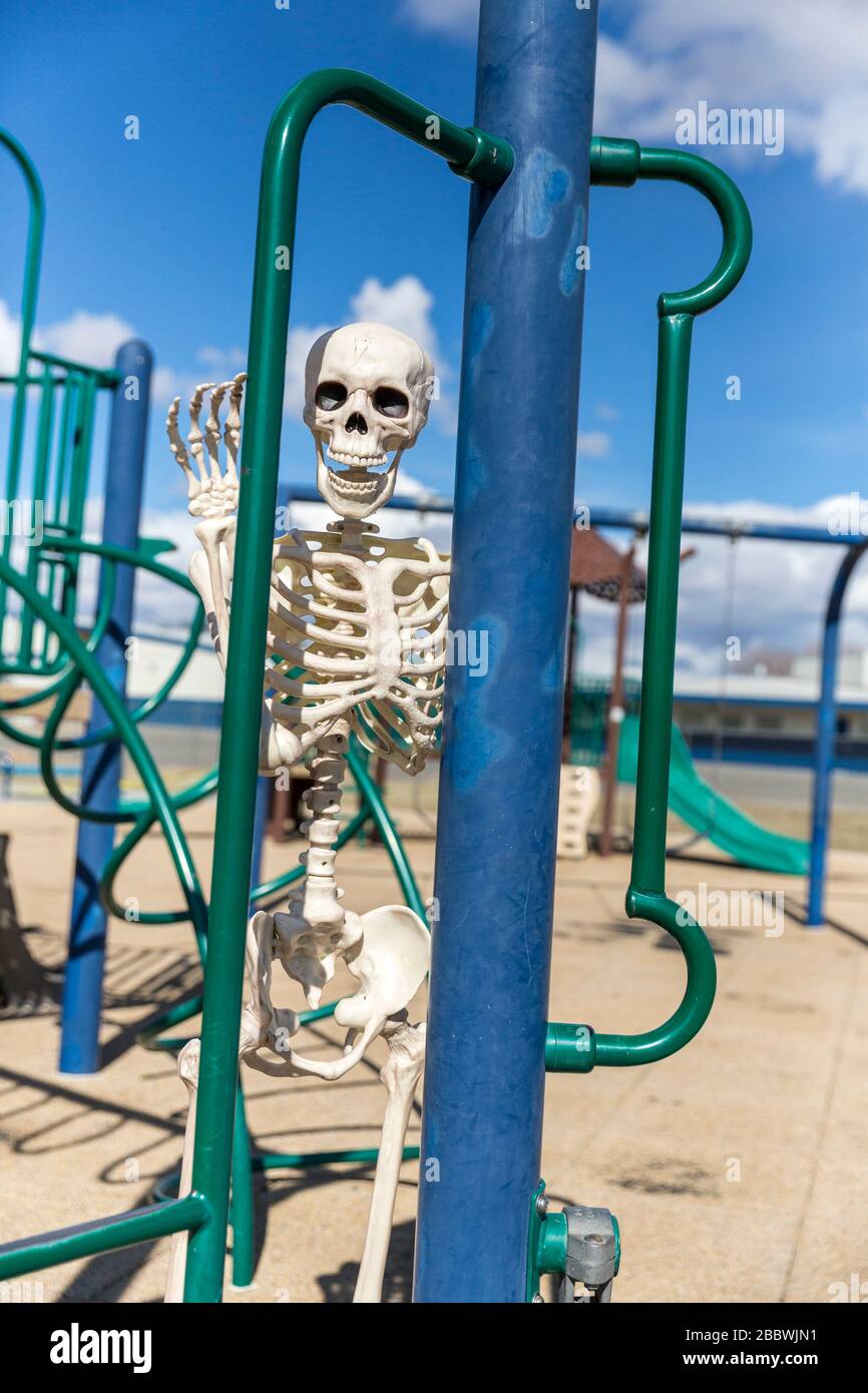 Skeleton hiding behind a child's toy in an empty park Stock Photo - Alamy