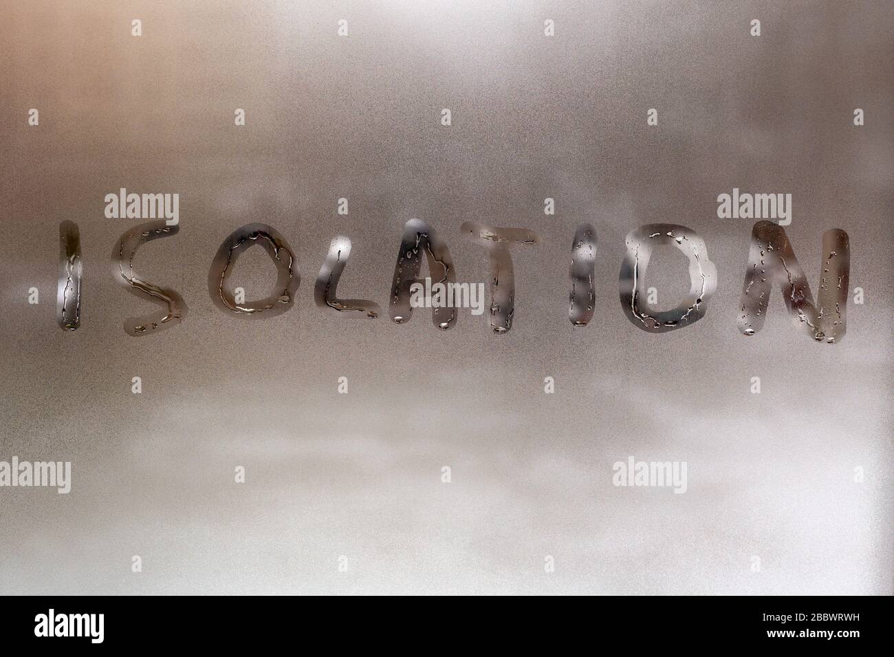the word isolation handwritten on wet window glass at cloudy weather ...