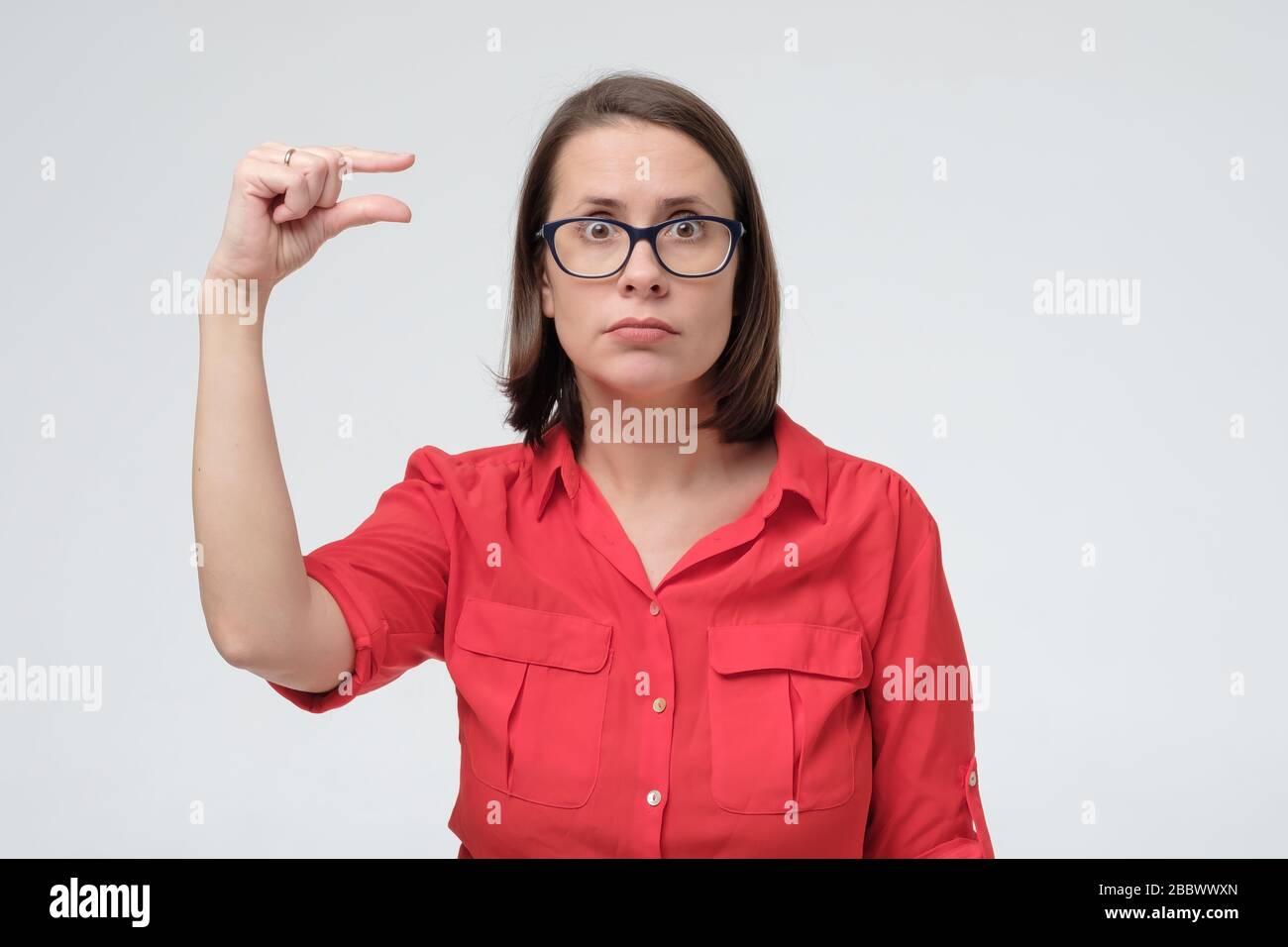 It is too small. Beautiful mature woman in red shirt gesturing small ...
