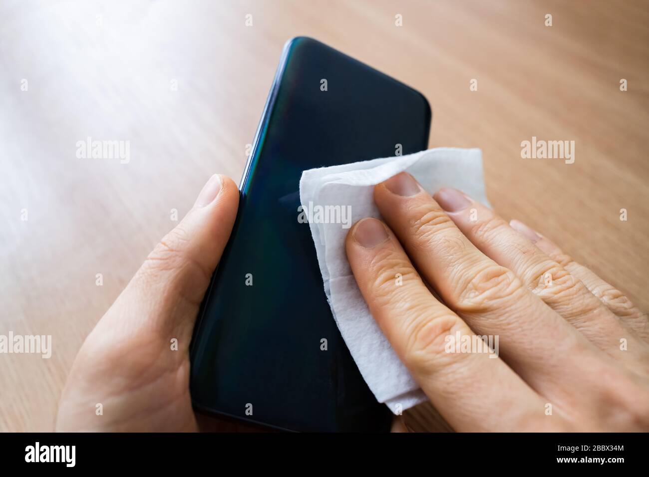 Man Wiping Mobile Phone Screen With Sanitizer Stock Photo - Alamy