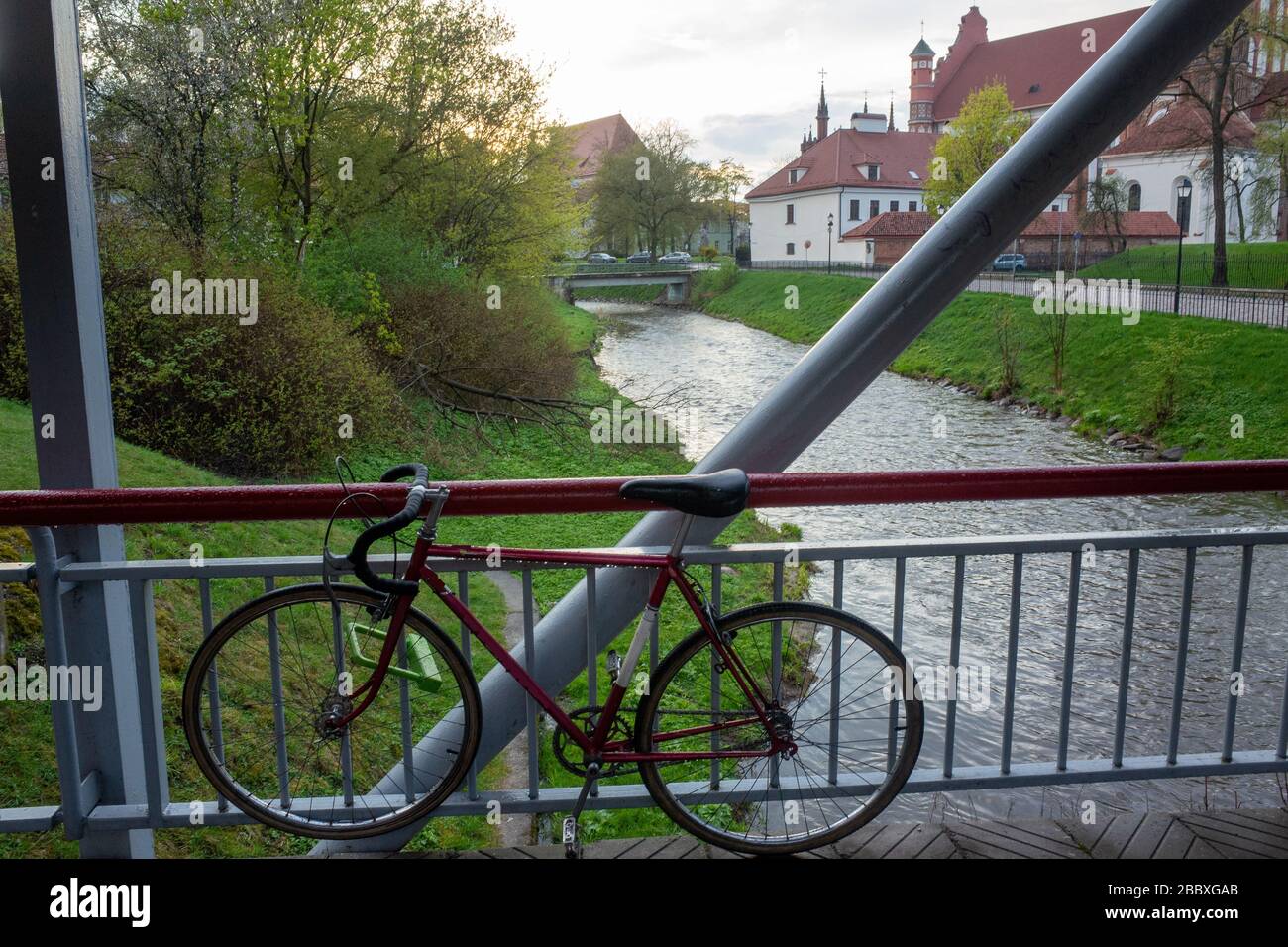 Road bike on the railing of a pedestrian bridge over a river in Vilnius ...