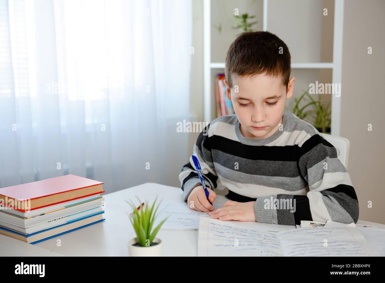 Child studying at home and doing school homework. Distance learning ...