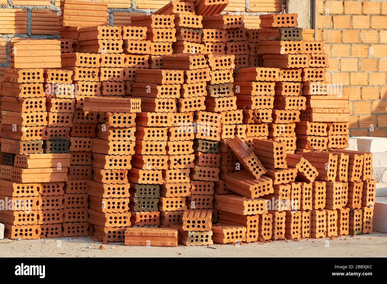 Red brick neatly stacked in rows for the construction of a residential ...