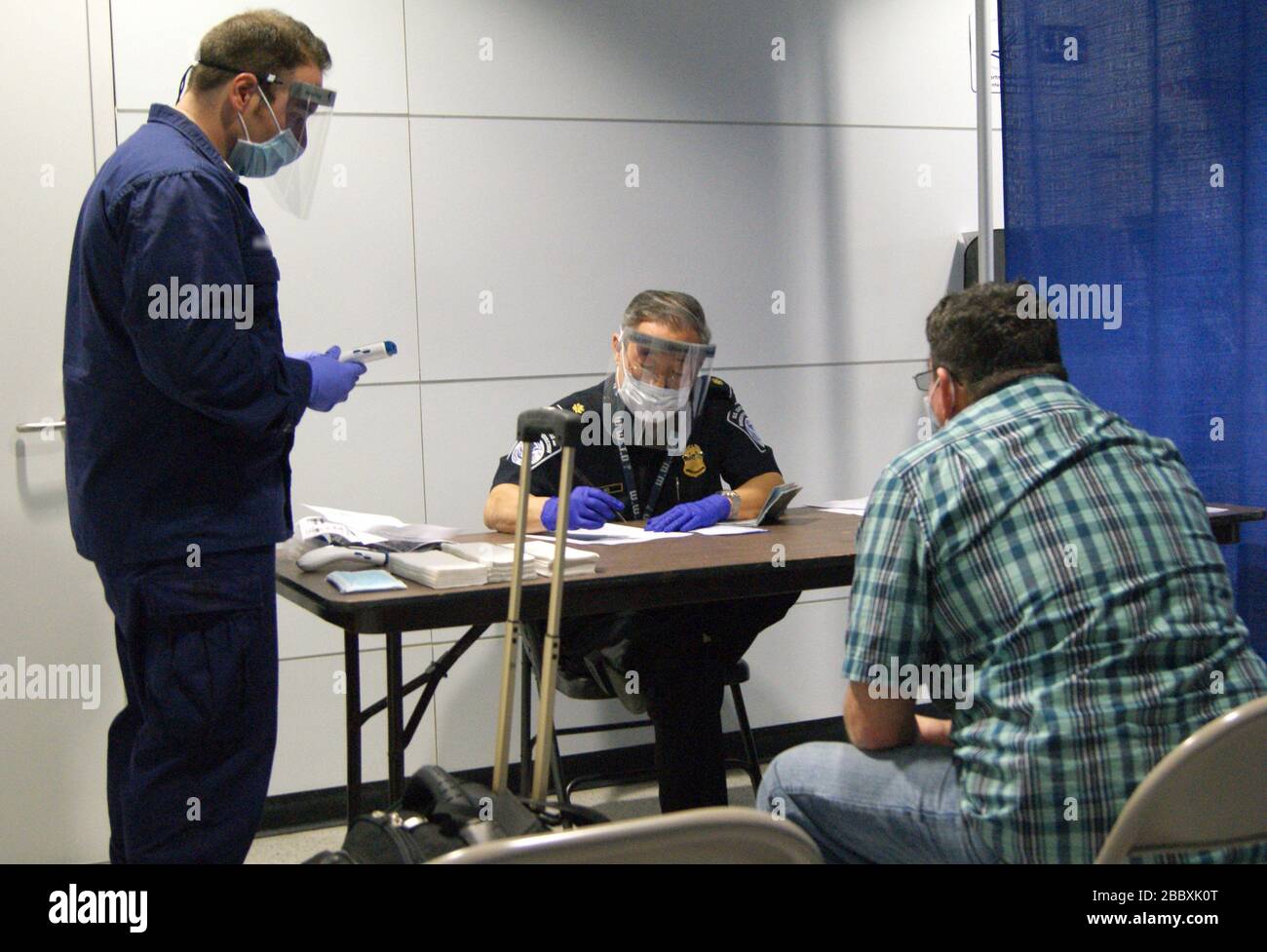 A U.S.C.G. Corpsman and CBP Supervisor conduct prescreening measures on ...