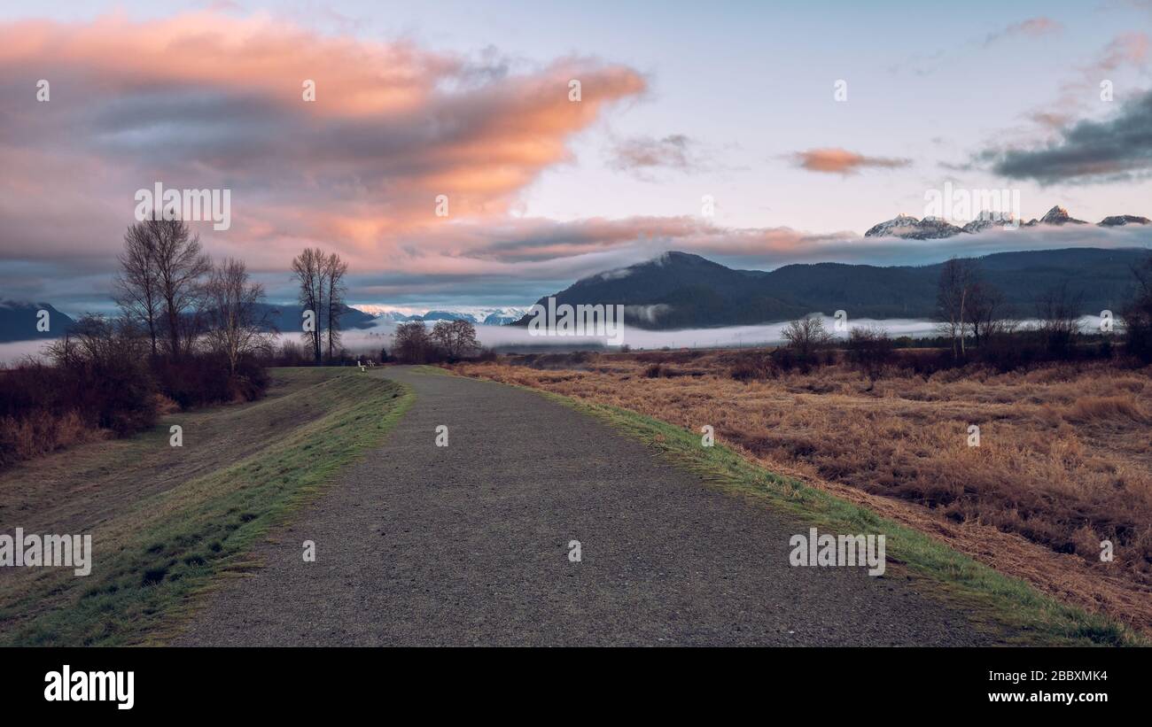 Gravel path with distant mountains and sunset in this dramatic ...