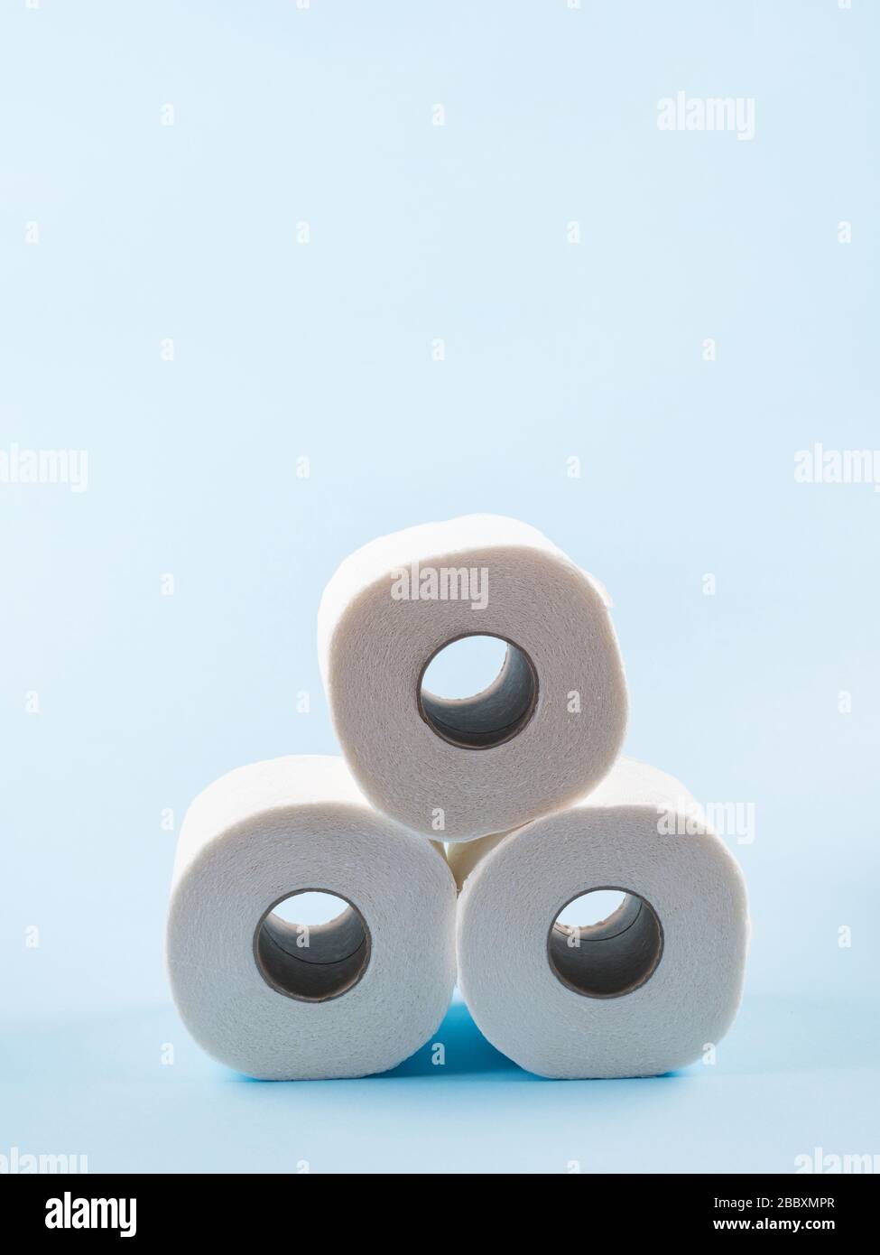 Stack of toilet paper rolls on blue backdrop Stock Photo - Alamy