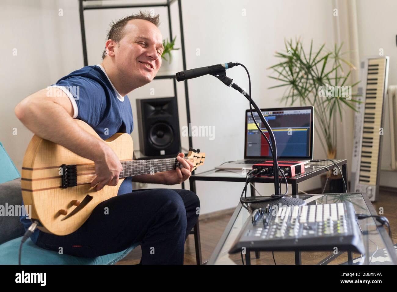 Professional musician recording electric guitar in digital studio at ...