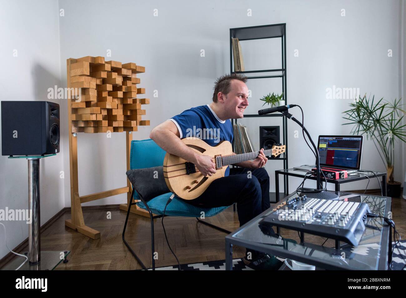 Professional musician recording electric guitar in digital studio at ...