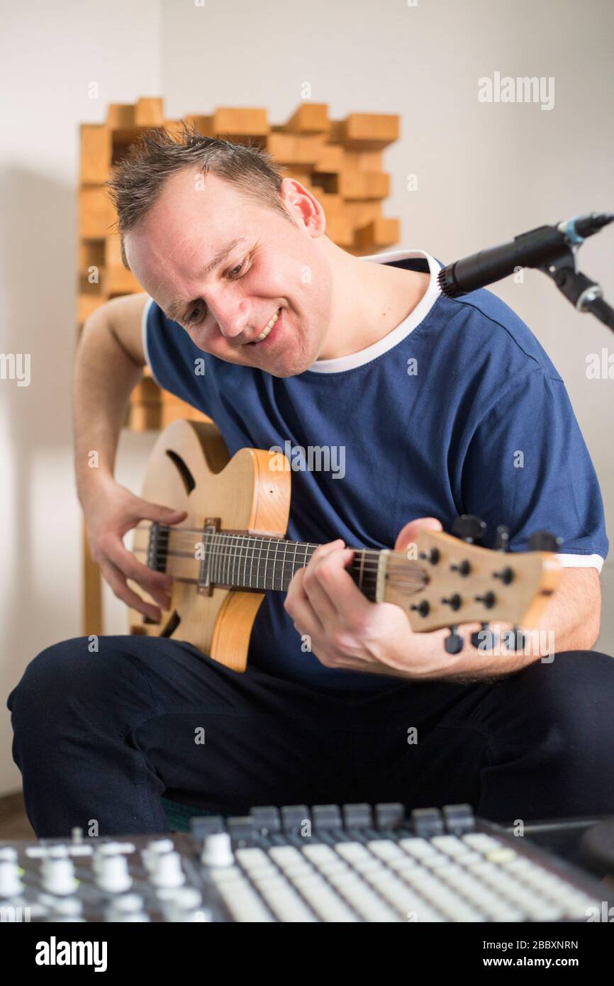 Professional musician recording electric guitar in digital studio at ...