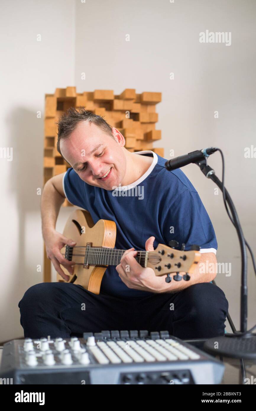 Professional musician recording electric guitar in digital studio at ...