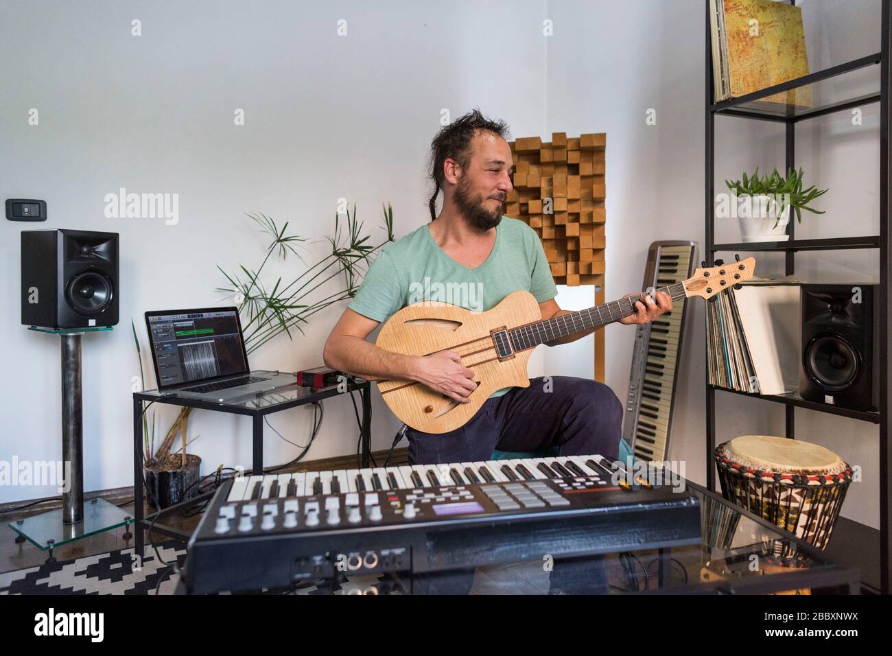 Professional musician recording electric guitar in digital studio at ...