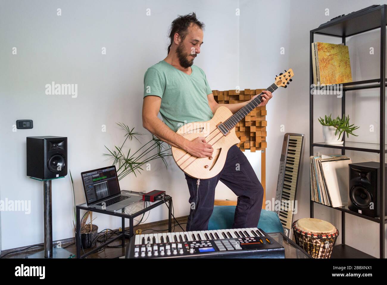 Professional musician recording electric guitar in digital studio at ...