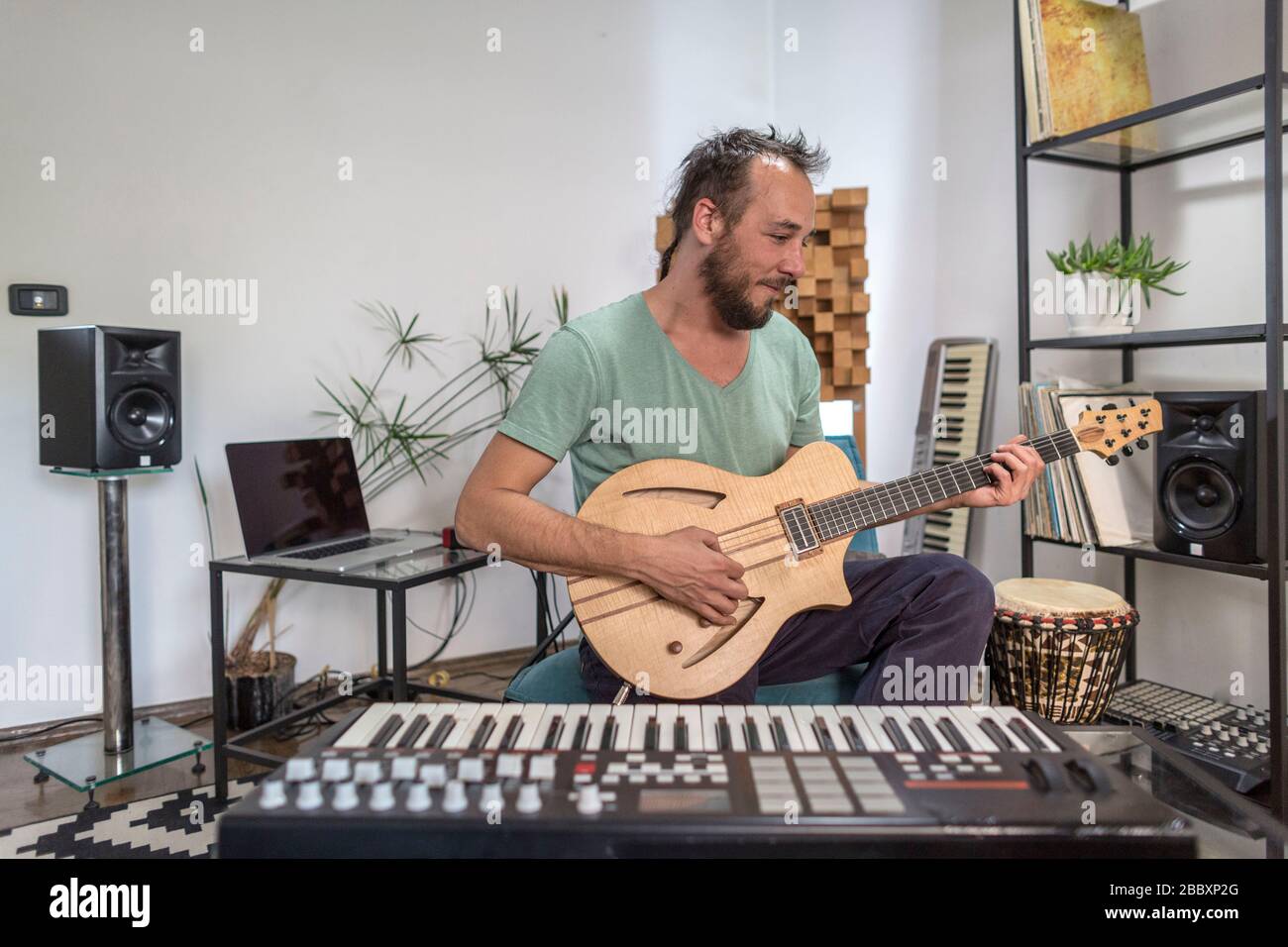 Professional musician recording electric guitar in digital studio at ...