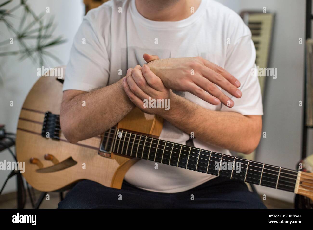 Professional musician having wrist pain while recording electric guitar ...