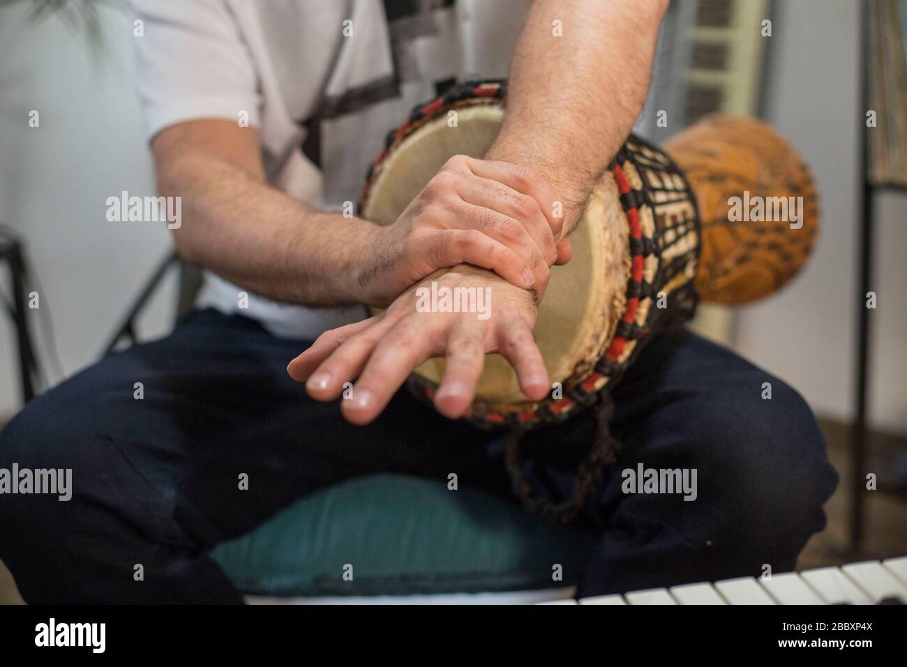 Professional musician having wrist pain while playing djembe music ...