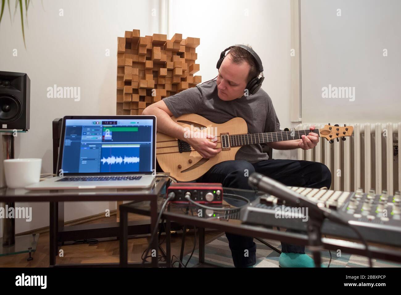 Professional musician recording electric guitar in digital studio at ...
