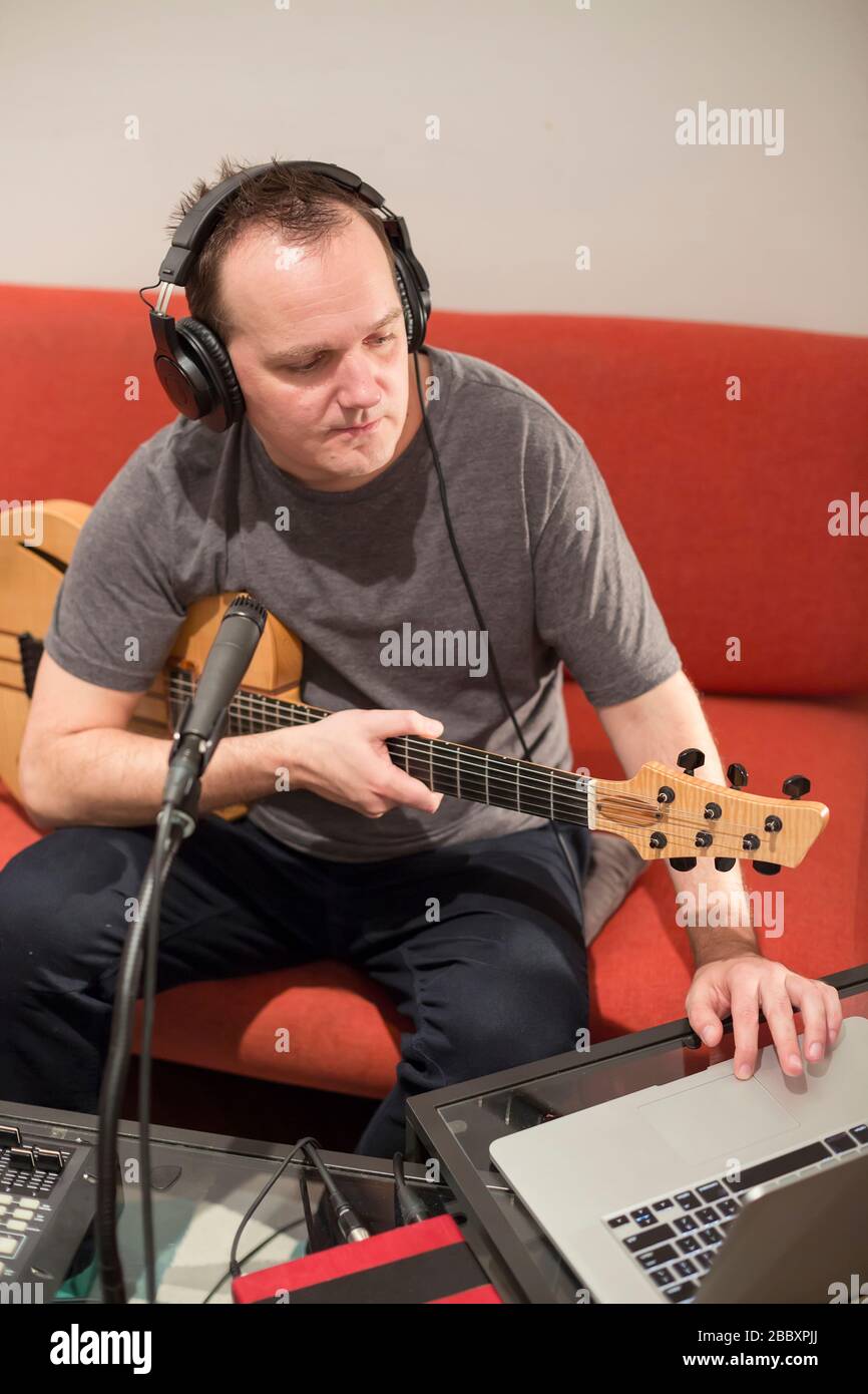 Professional musician recording electric guitar in digital studio at ...