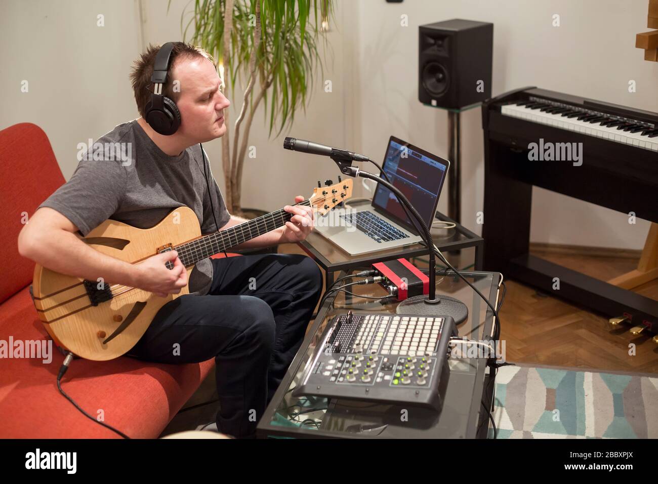 Professional musician recording electric guitar in digital studio at ...