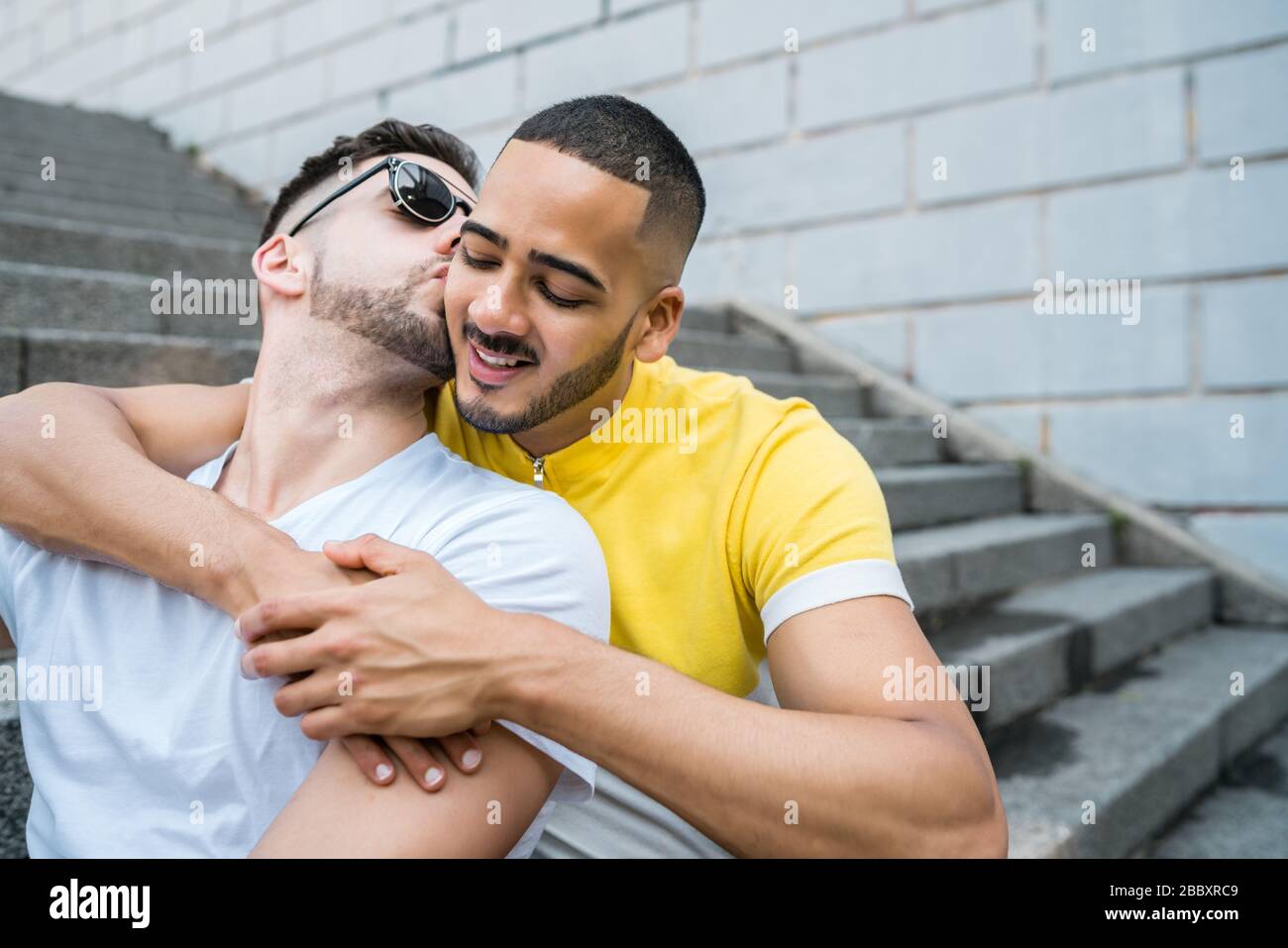 Portrait of happy gay couple spending time together while sitting on ...