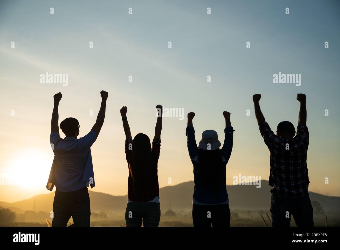 Group of happy friends are having fun with raised arms together in ...