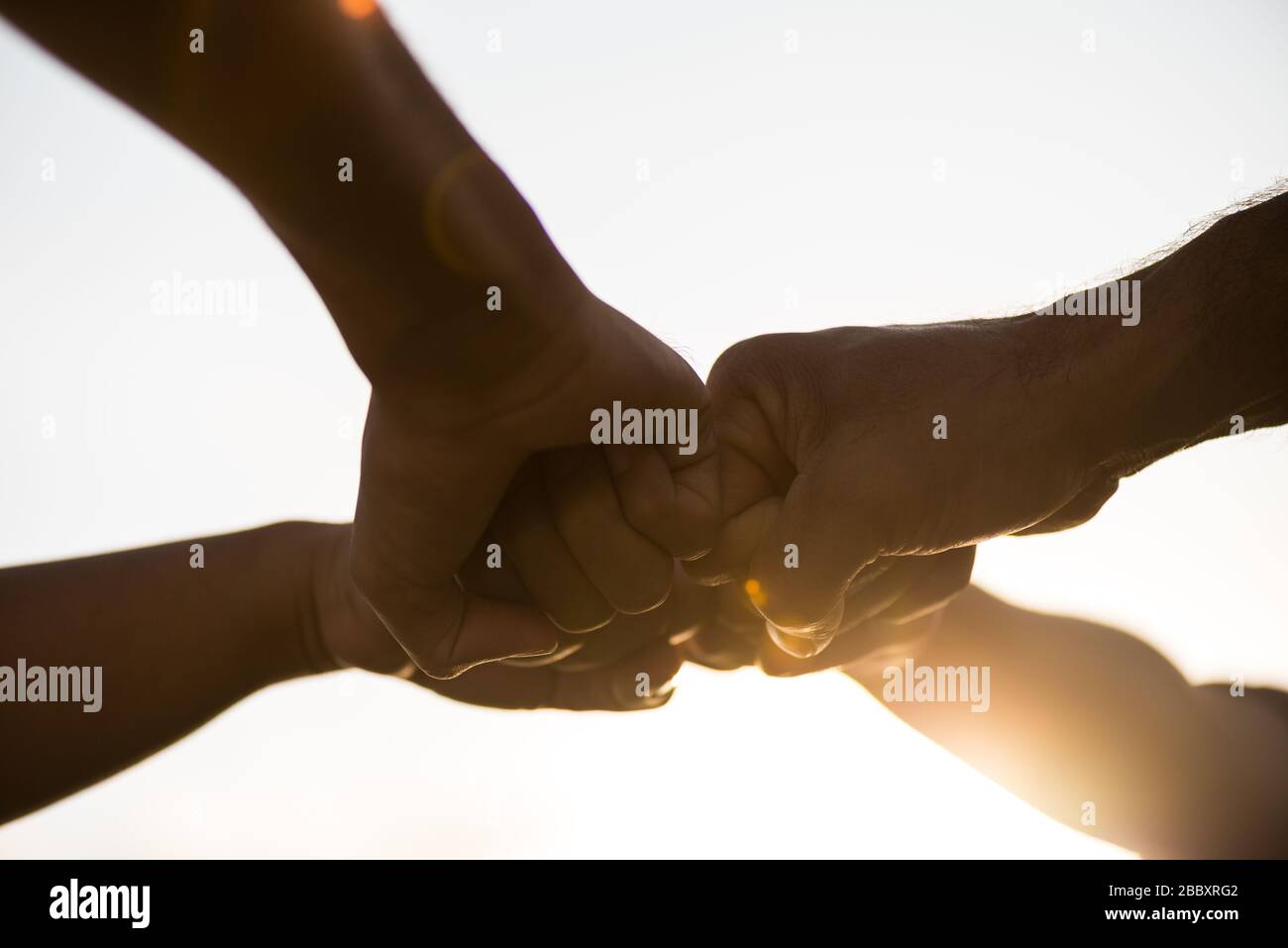 Close up bottom view of people giving fist bump showing unity and ...