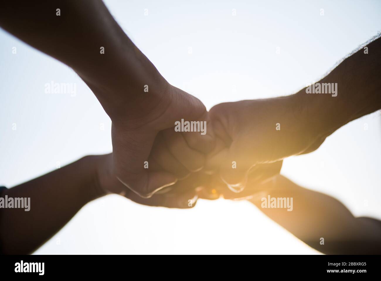 Close up bottom view of people giving fist bump showing unity and ...