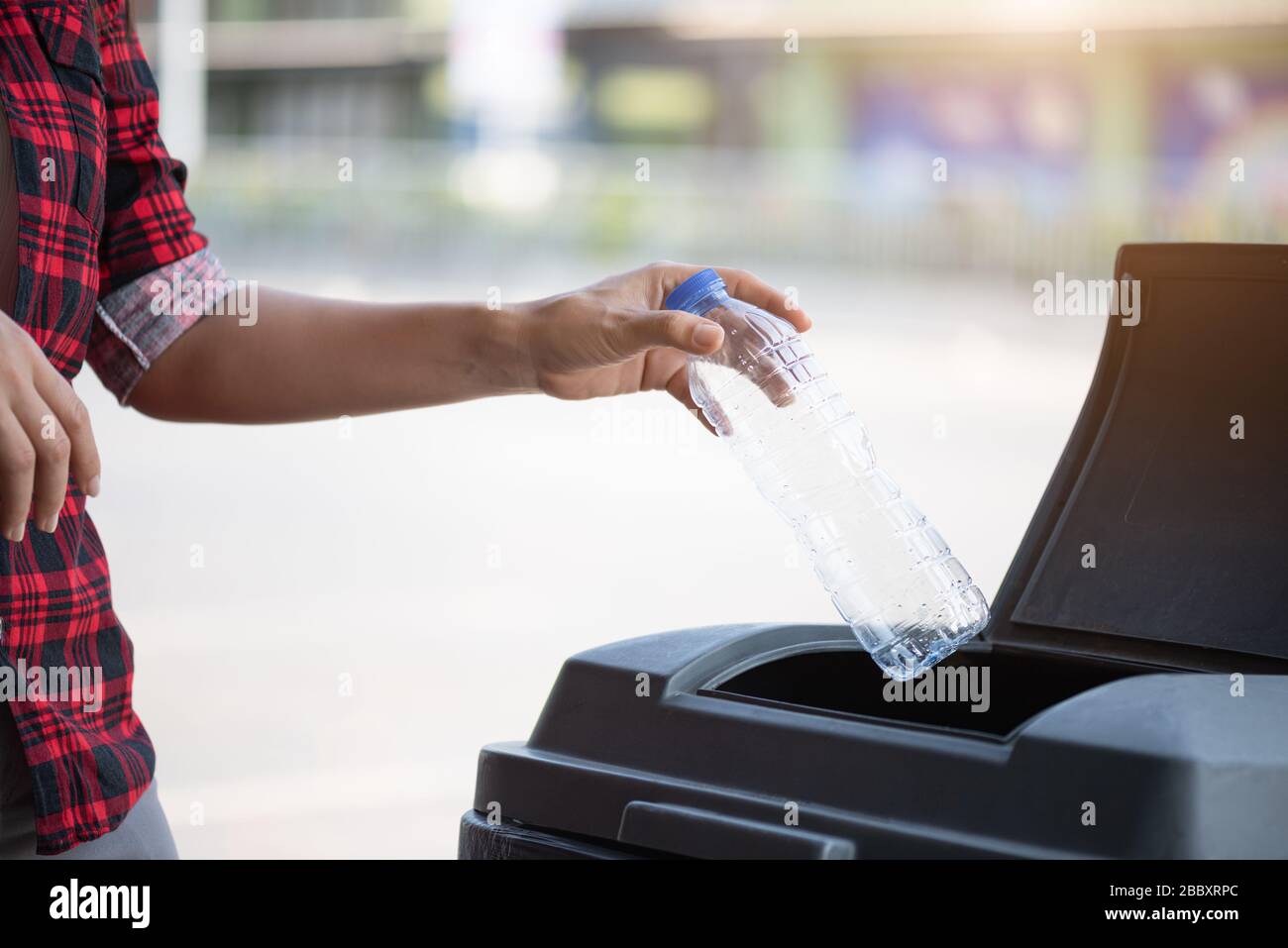 Closeup portrait woman hand throwing empty plastic water bottle in ...