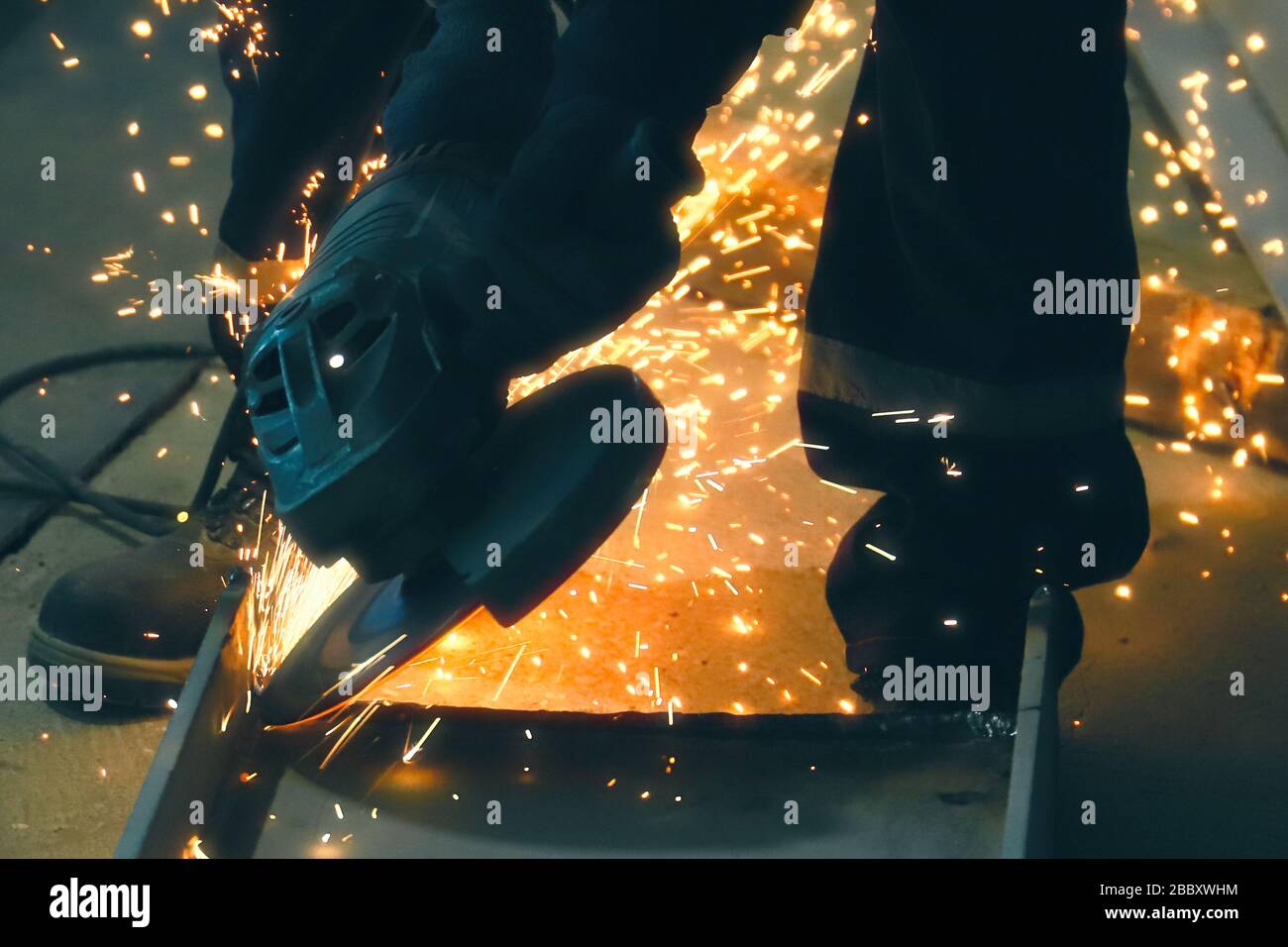 Professional worker cuts metal by angle grinder machine. Fountain of ...