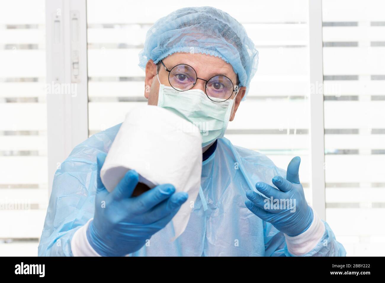 Doctor in protective suit offers as help a toilet paper. Medical ...