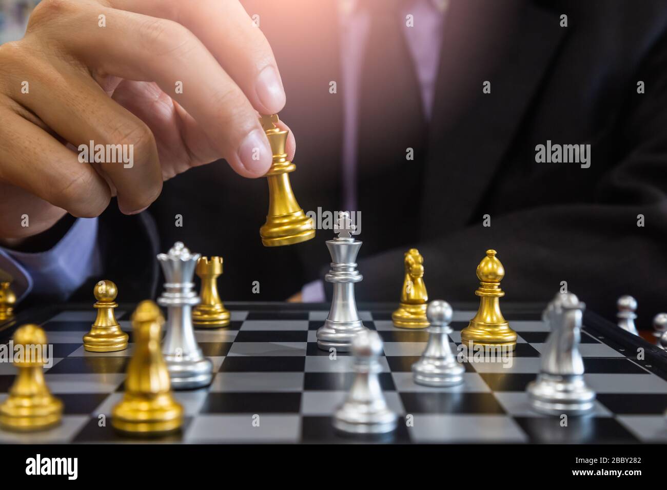 Chess game on chess board behind business man background. Business ...