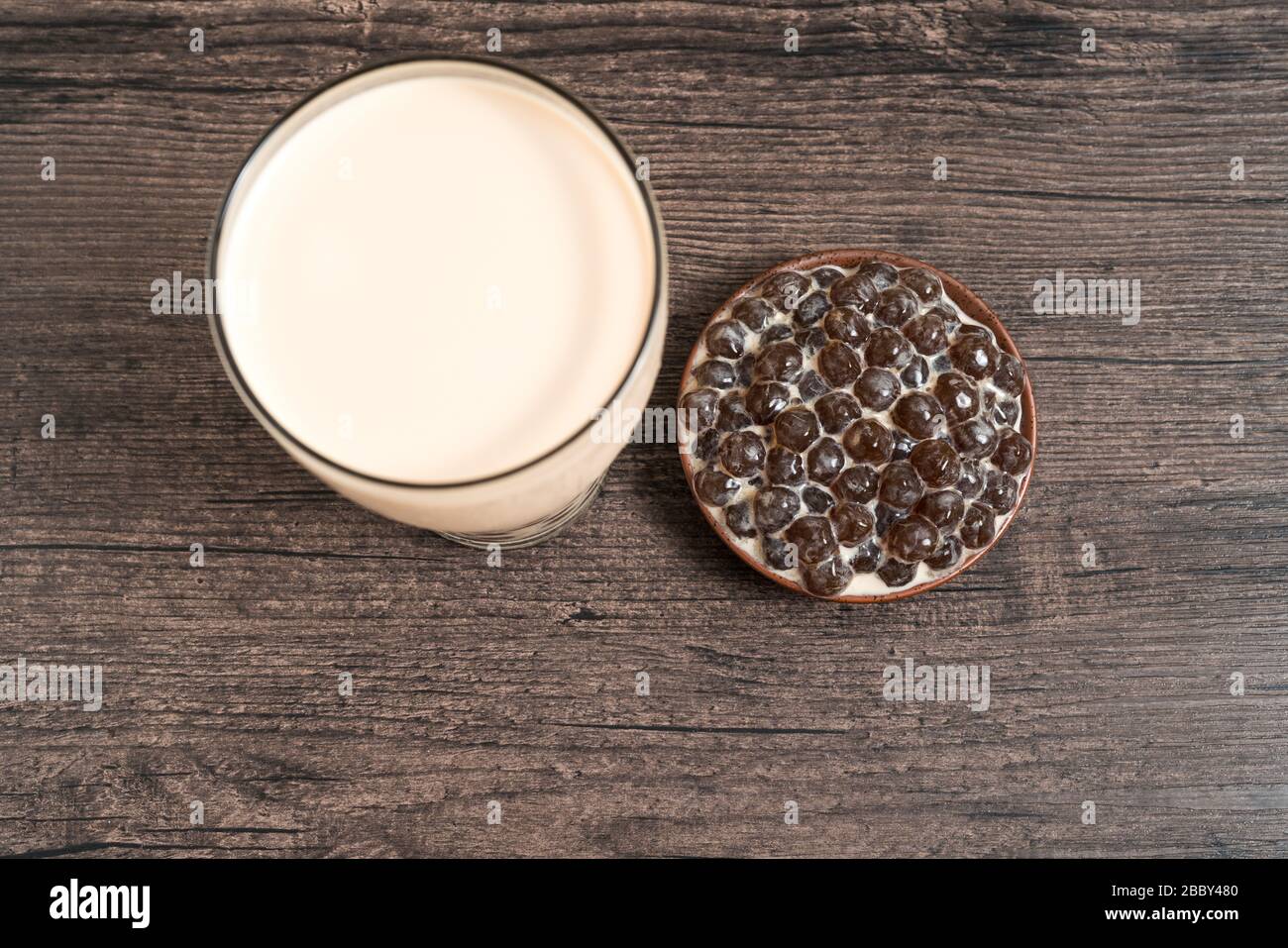 A glass cup of pearl milk tea (also called bubble tea) and a plate of ...