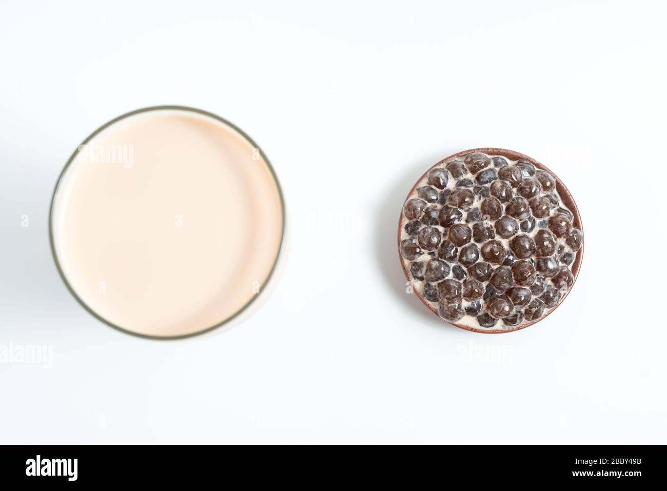 A glass cup of pearl milk tea (also called bubble tea) and a plate of ...