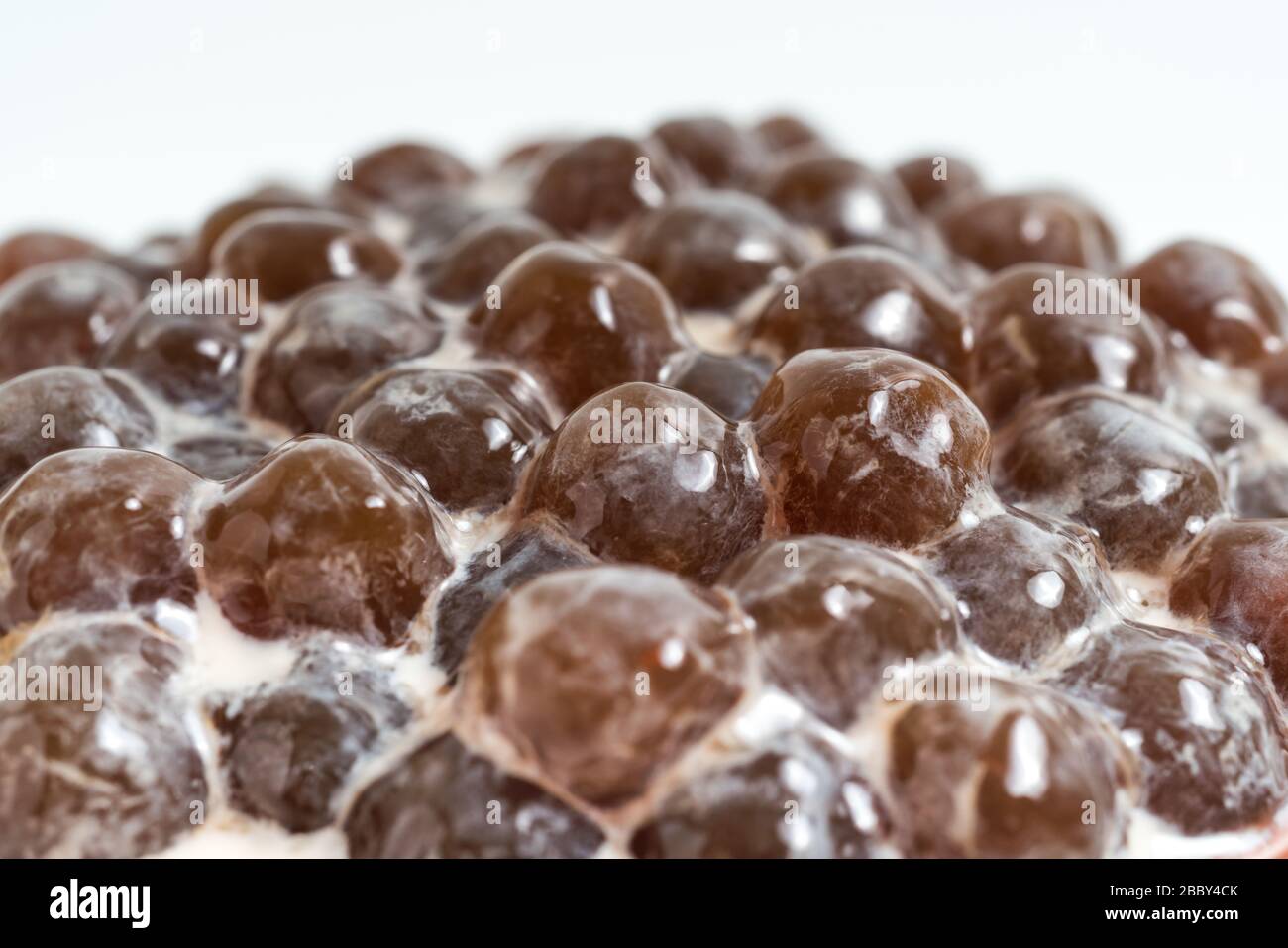 A glass cup of pearl milk tea (also called bubble tea) and a plate of ...