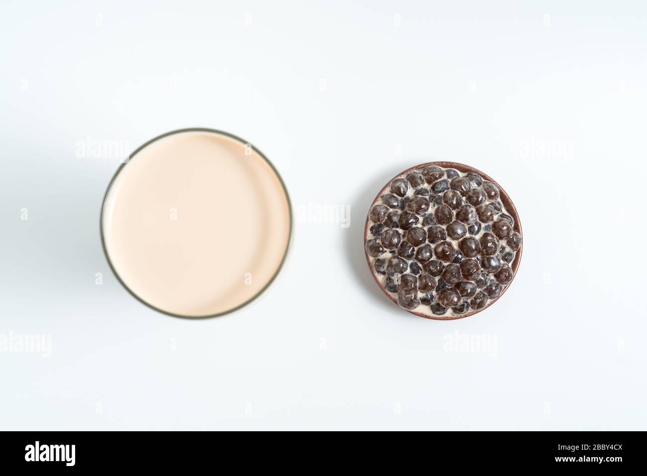 A glass cup of pearl milk tea (also called bubble tea) and a plate of ...