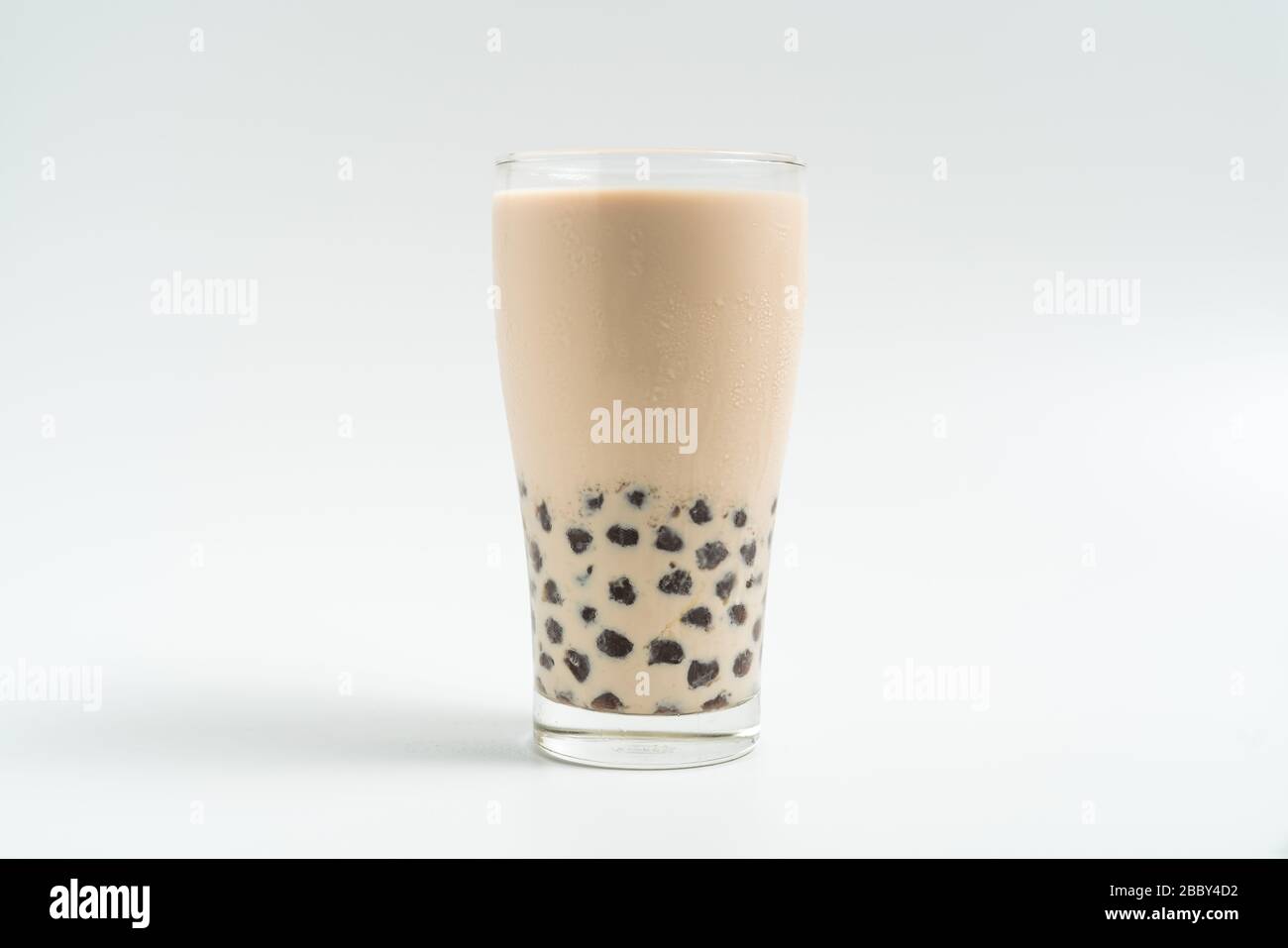 A glass cup of pearl milk tea (also called bubble tea) and a plate of ...
