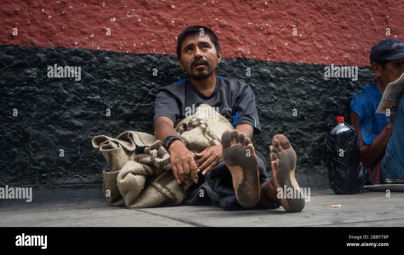 Lima, Peru. 01st Apr, 2020. A barefoot young man waiting to be allowed ...