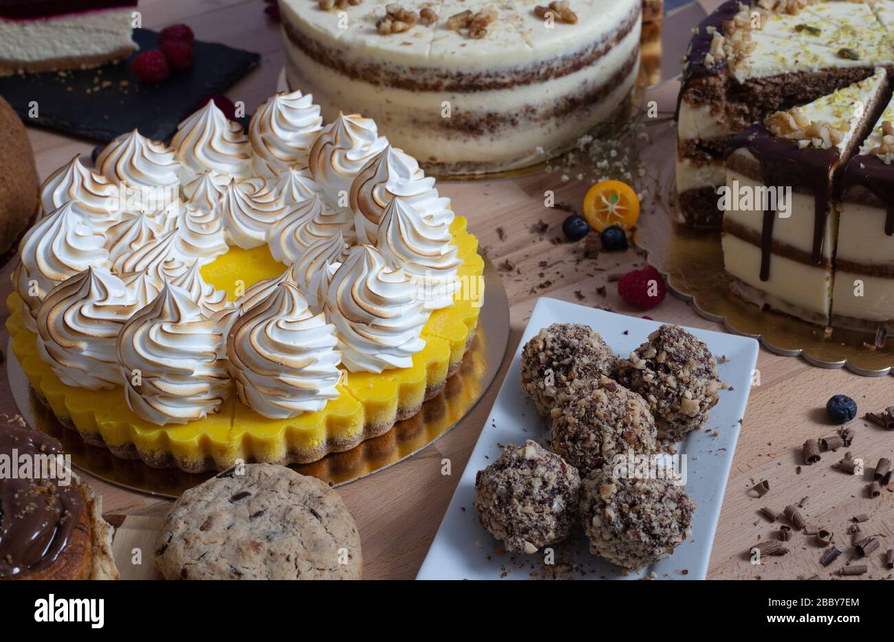 Various cakes on wooden table. Assortment of cakes for celebrations ...