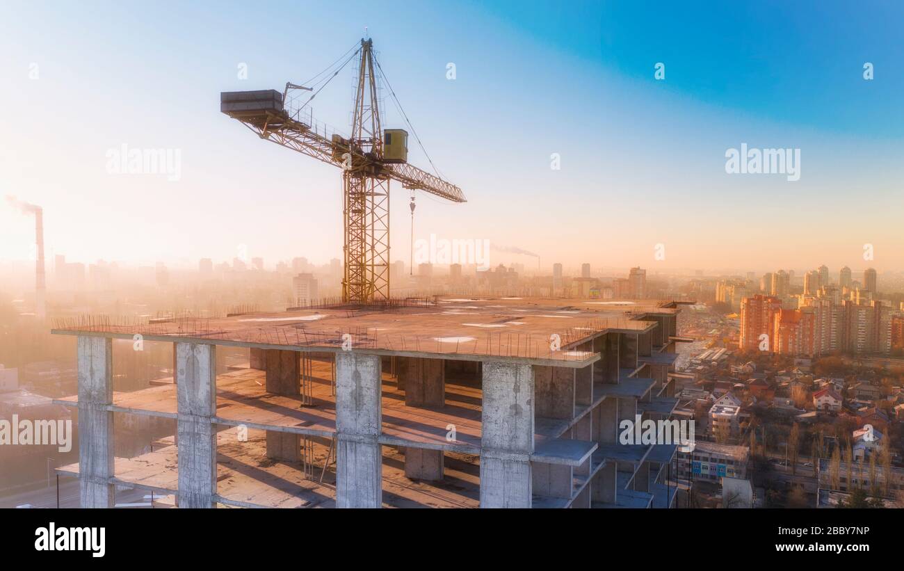 Multi-storey building, tower crane and construction site, top view. At ...