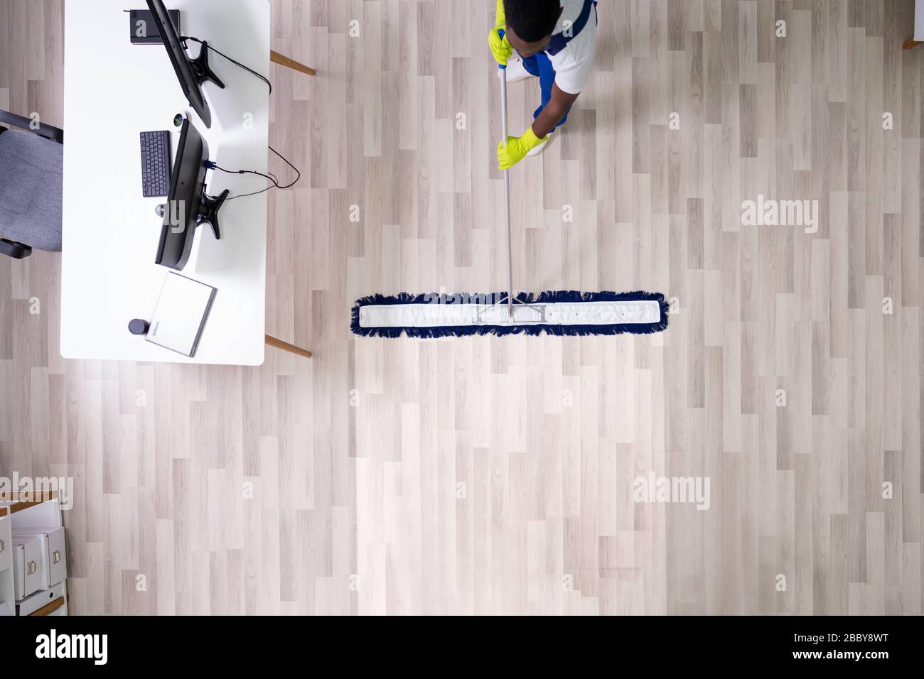 Man With Mop And Wet Floor Sign Stock Photo - Alamy