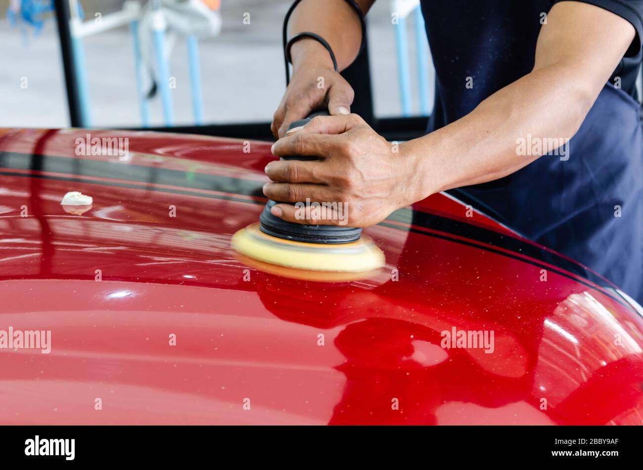 Car detailing - Car care service. Man holding a polisher in his hand ...