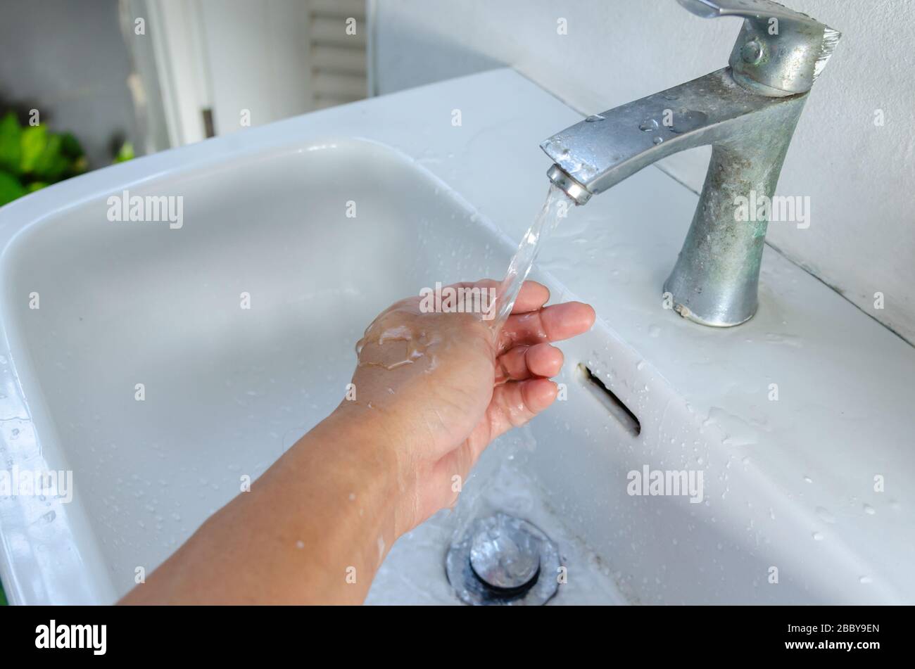 A man's hand washing hands at the faucet Stock Photo - Alamy