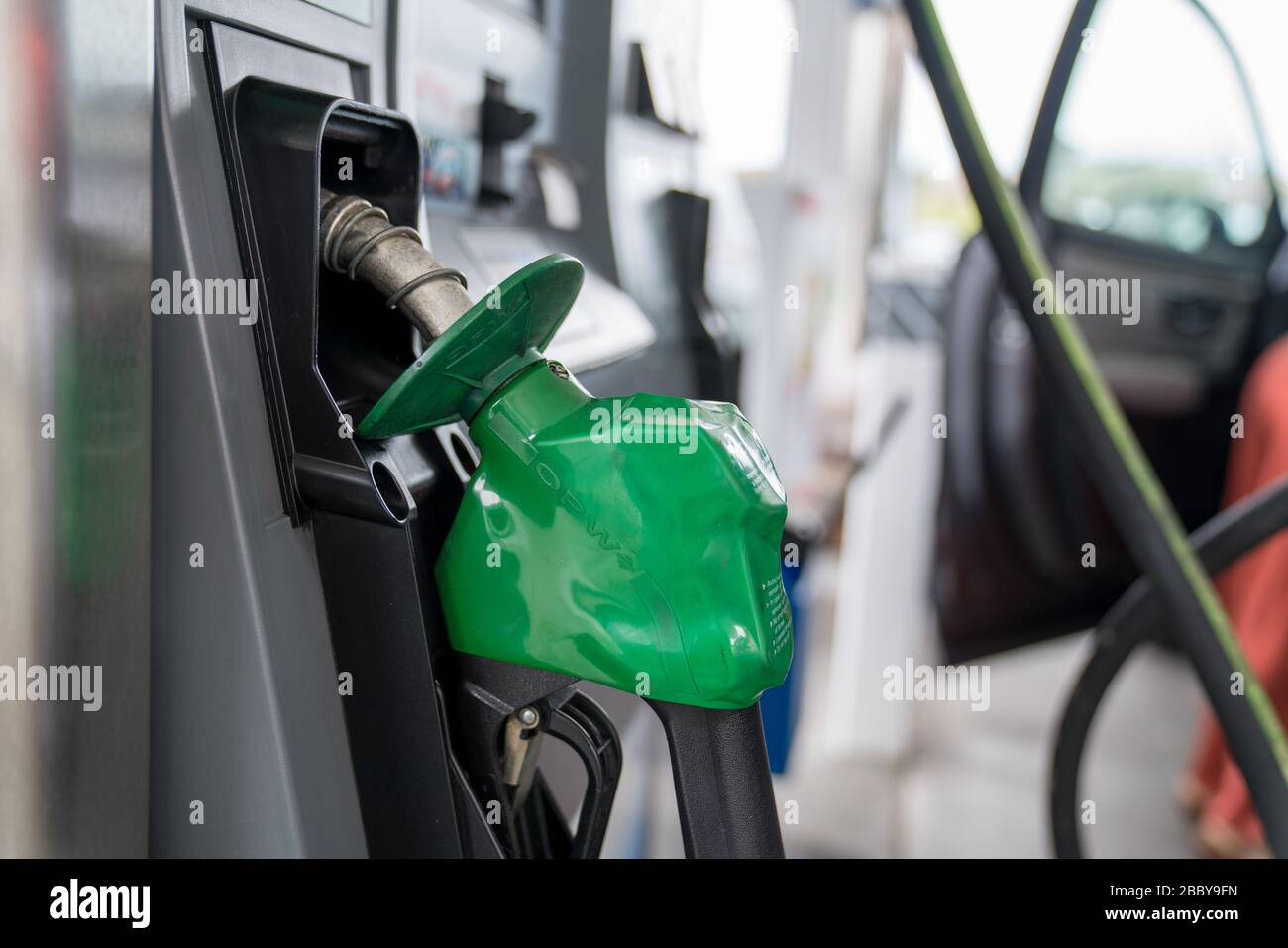 Green diesel fuel nozzle in resting position at gas station pump Stock ...