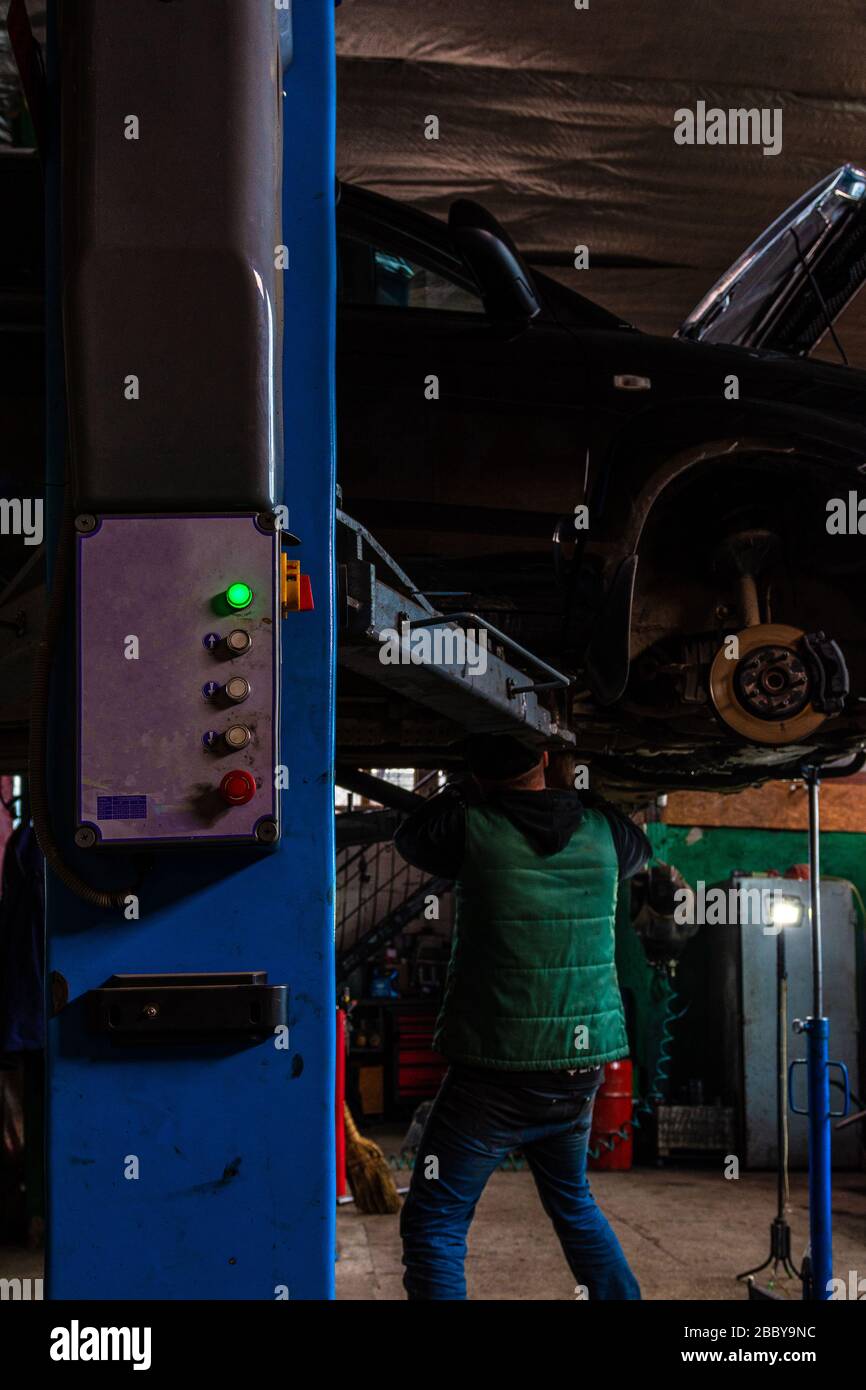 The mechanic lifted the car with a lift to service the engine 2020 ...