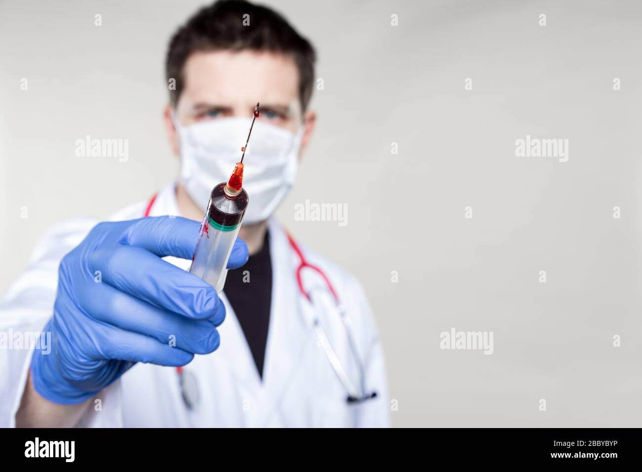 doctor holds a syringe in his hand filled with red liquid, concept of ...
