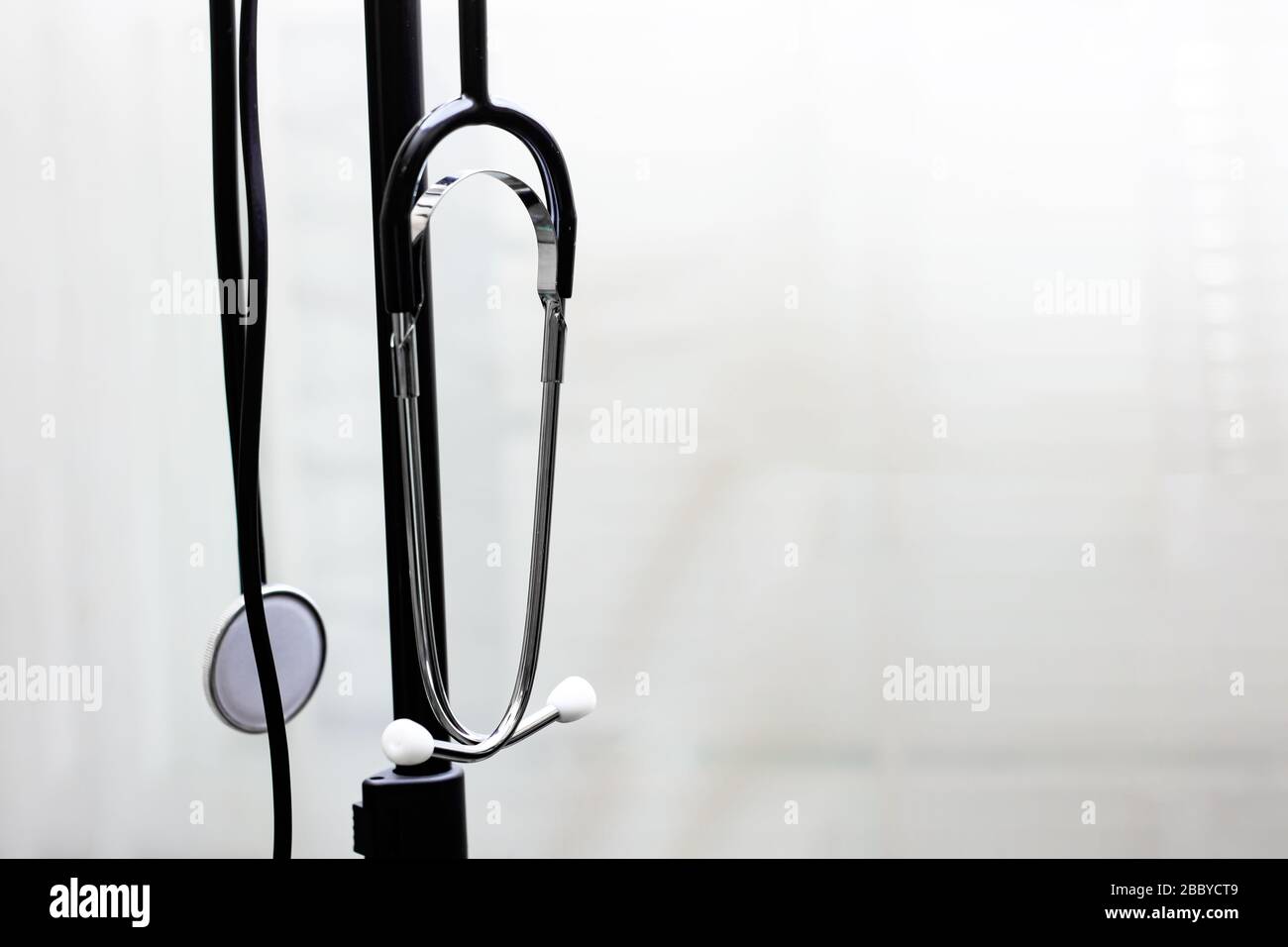 Stethoscope hanging on a black stand on a white background Stock Photo ...