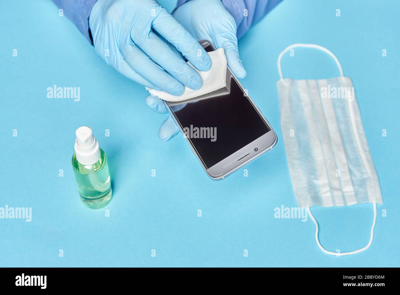 smartphone disinfection. a man wipes a phone screen with a sanitizer ...