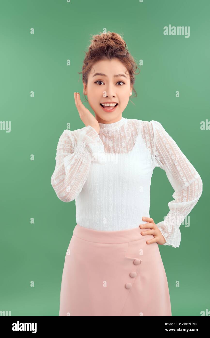 Attrative young Asian woman standing islated over green background ...