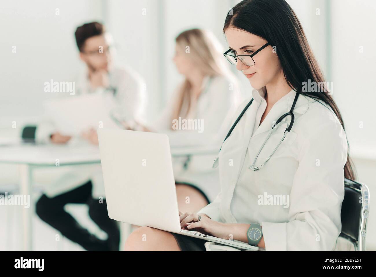 therapist with a laptop sitting in the hospital office .photo with copy ...