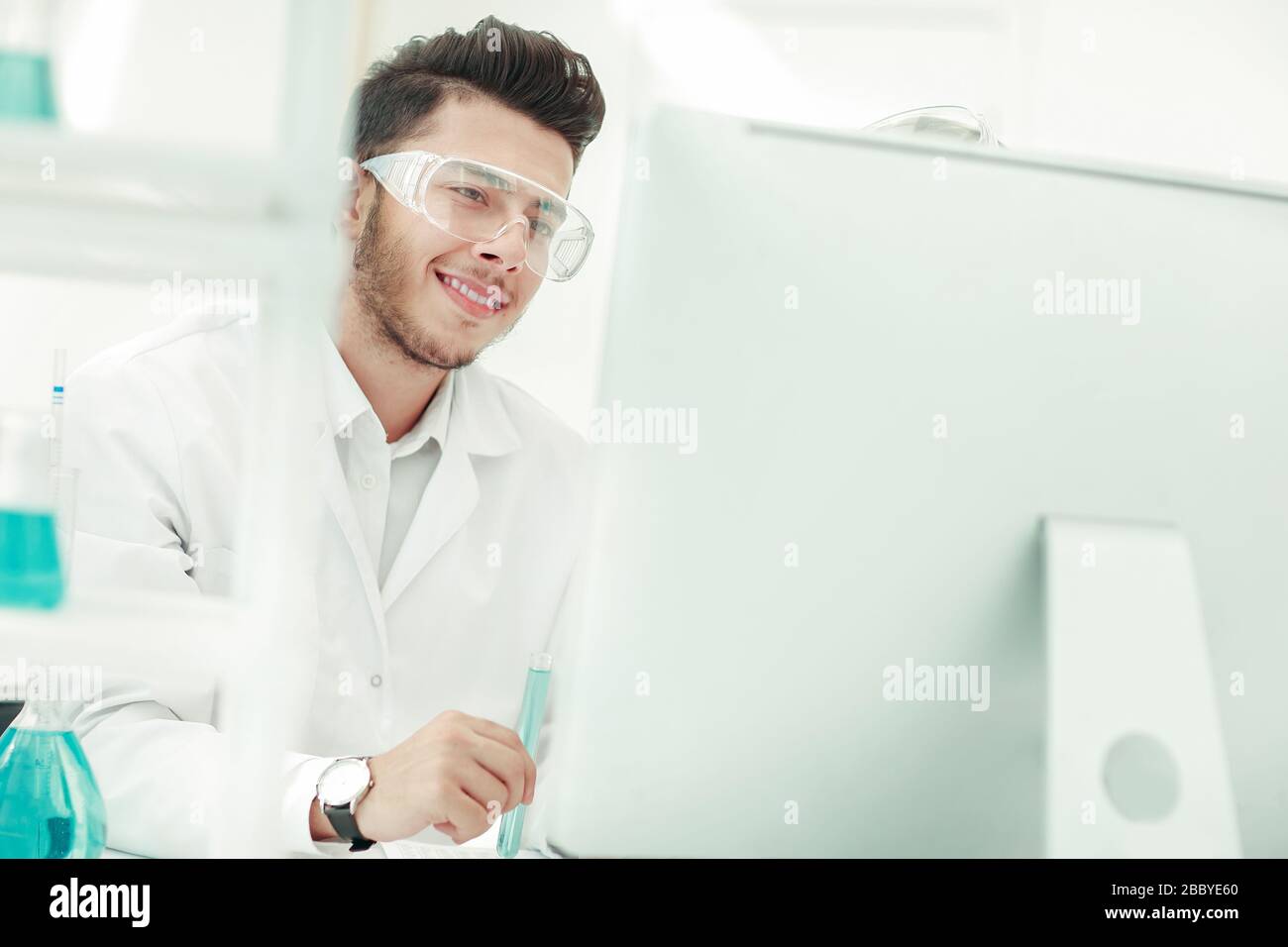 close up. young scientist looking at computer monitor. science and ...