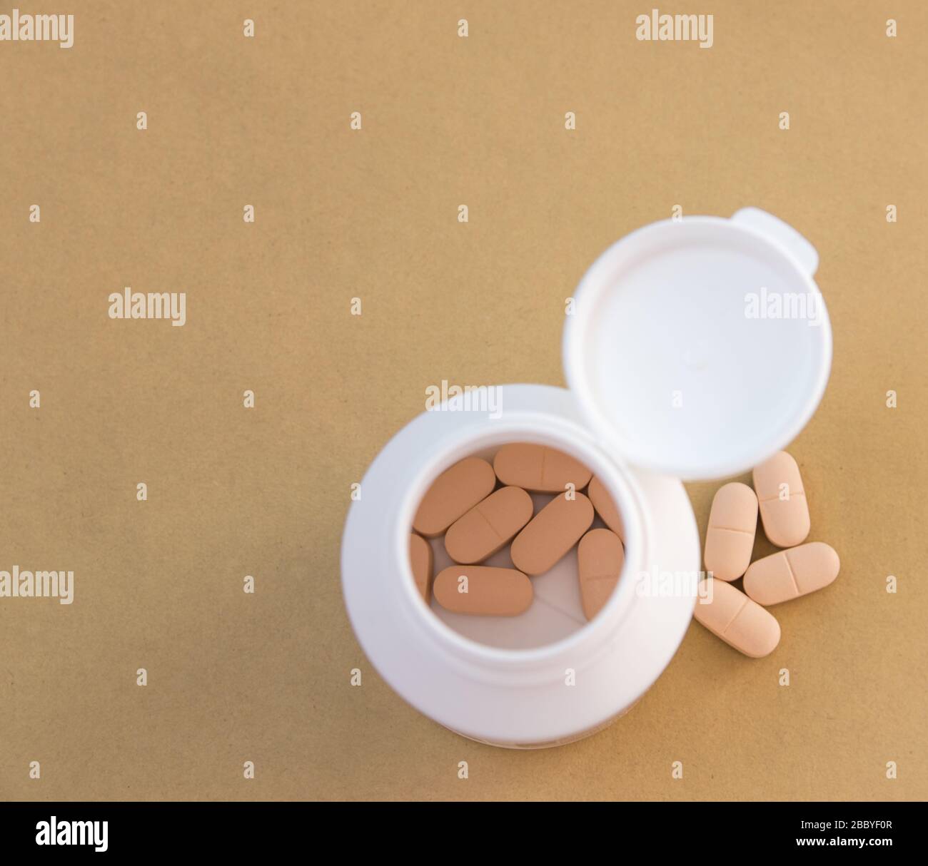 Tablets in white open bottle on the yellow nature background. Farmacy ...